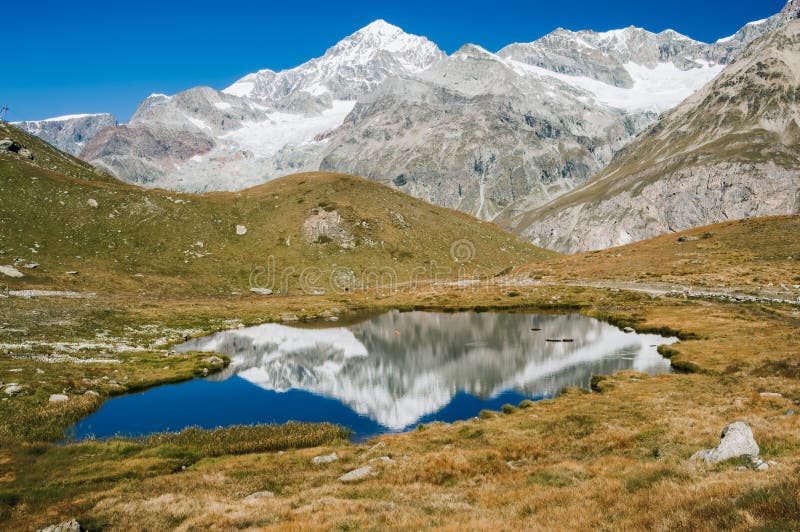 A Mirror-like Reflection of the Sky and Surrounding Mountains, Swiss ...