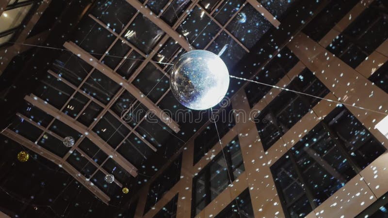 A Mirrored Disco Ball Suspended from the Ceiling Inside a High-rise ...