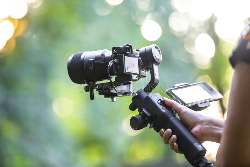 A Girl Operating Camera Mounted on a Gimbal, Focus on the Gimbal and ...
