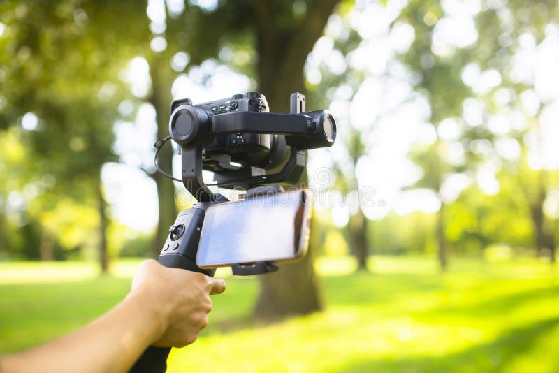 A Girl Operating Camera Mounted on a Gimbal, Focus on the Gimbal and ...
