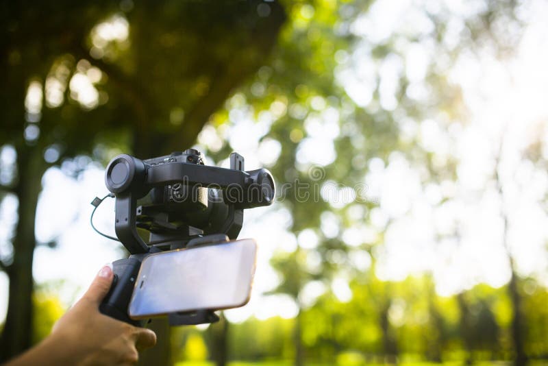 A Girl Operating Camera Mounted on a Gimbal, Focus on the Gimbal and ...