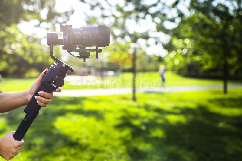 A Girl Operating Camera Mounted on a Gimbal, Focus on the Gimbal and ...