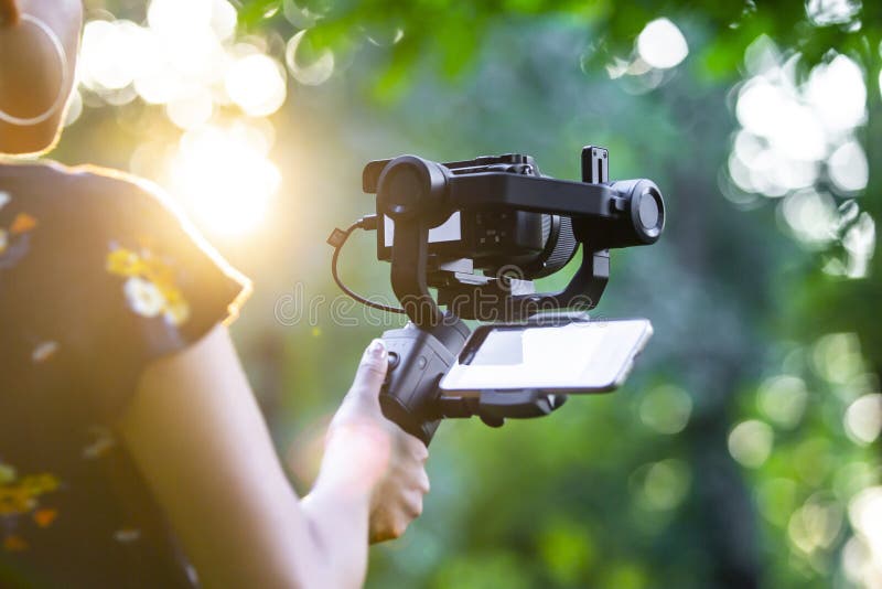 A Girl Operating Camera Mounted on a Gimbal, Focus on the Gimbal and ...