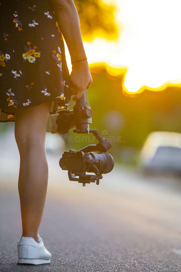 A Girl Operating Camera Mounted on a Gimbal, Focus on the Gimbal and ...