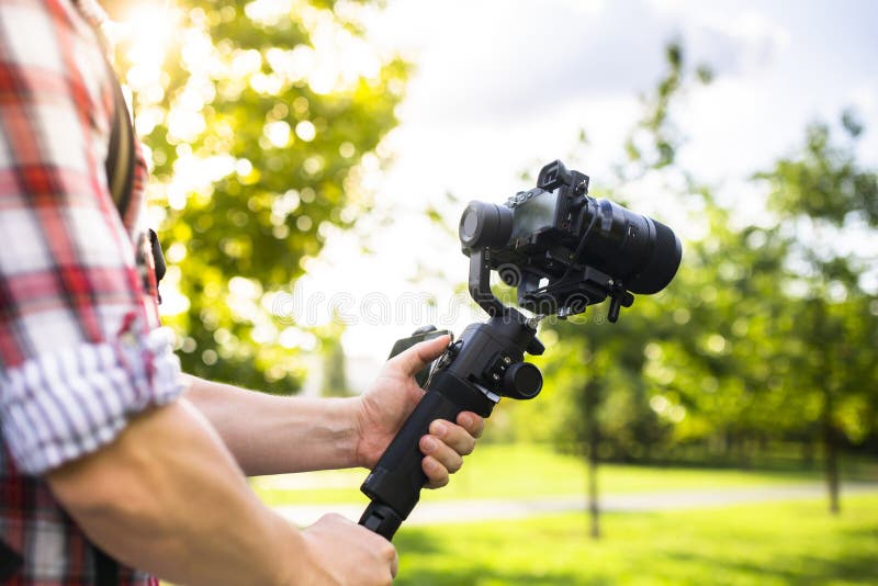 A Man Operating Camera Mounted on a Gimbal, Focus on the Gimbal and ...