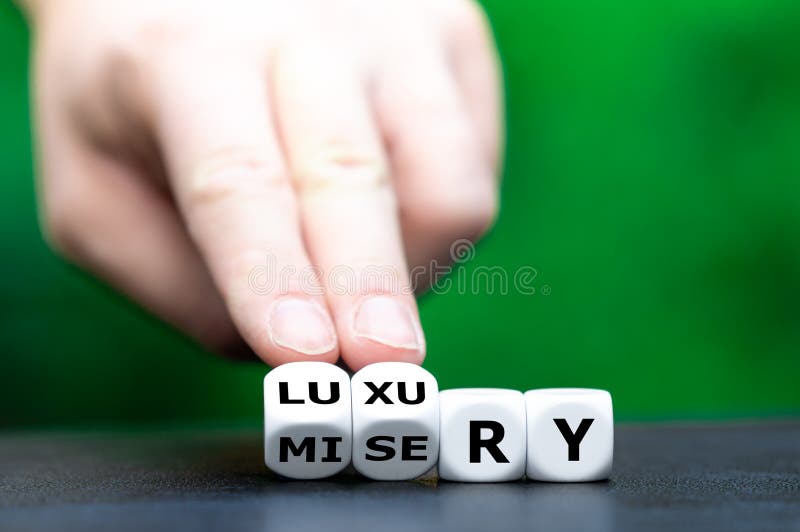 From Misery To Luxury. Hand Turns Dice and Changes the Word Misery To ...