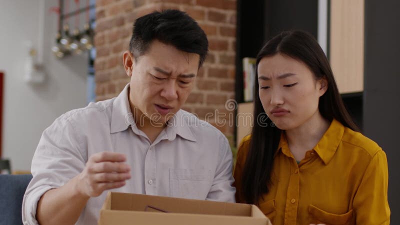 Upset Asian Spouses Looking at Cardboard Box, Having Problems with ...