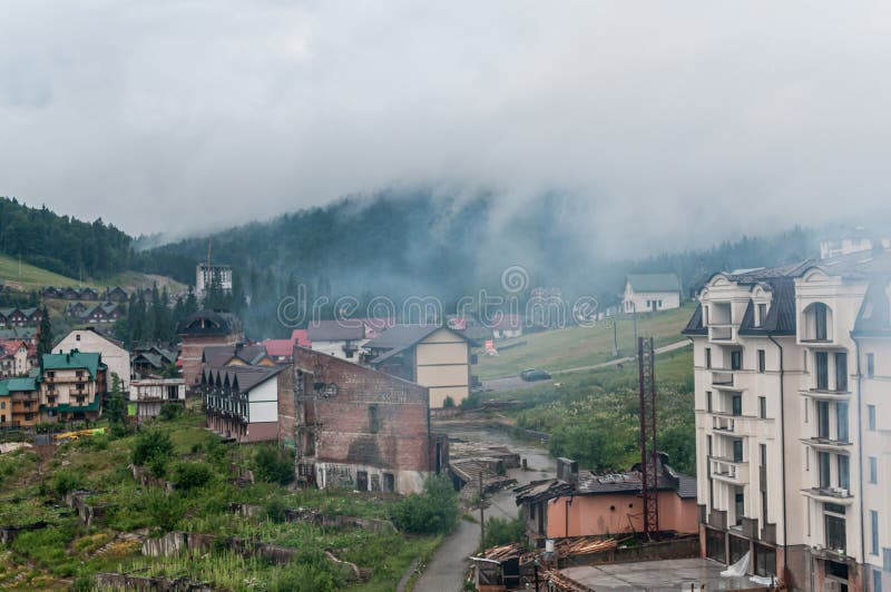 Misty Mountain Village with Rustic Architecture and Lush Greenery Stock ...