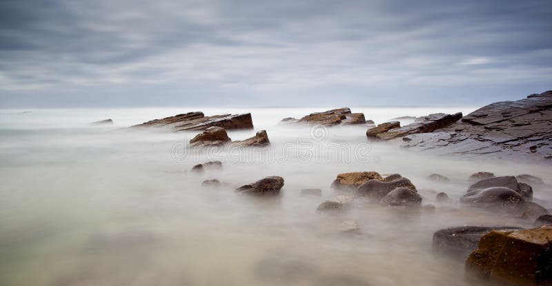 Misty sea and rocks stock photo. Image of beauty, movement - 23640022
