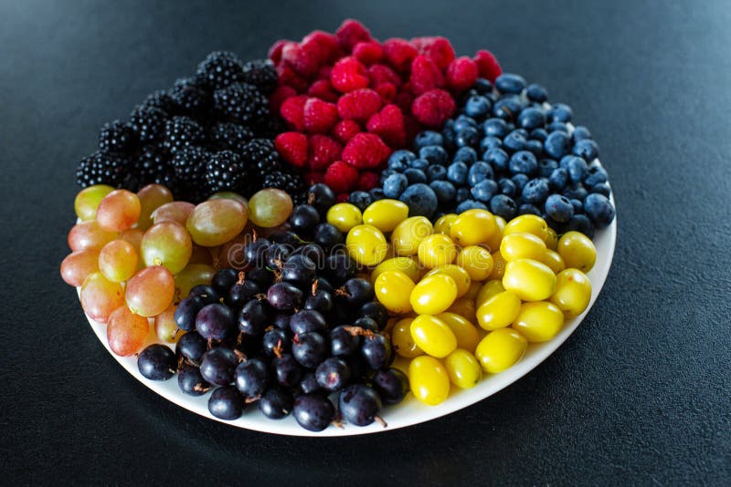 Mix of Colored Berries in a Round Plate Divided by Triangles. Stylish ...