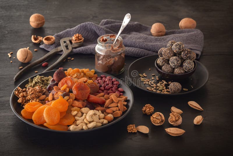 Mix of Dried Fruits, Energy Bites, Chocolate Paste and Nuts on a Black ...