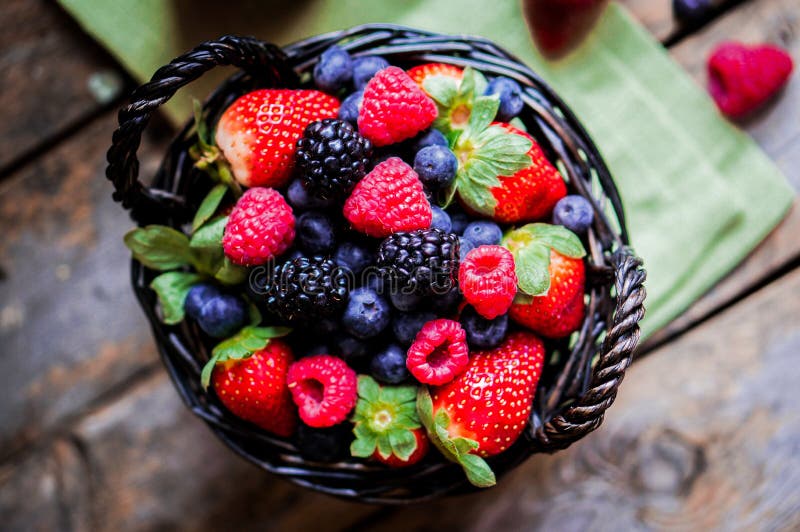 Mix of Fresh Berries in a Basket on Rustic Wooden Background Stock ...