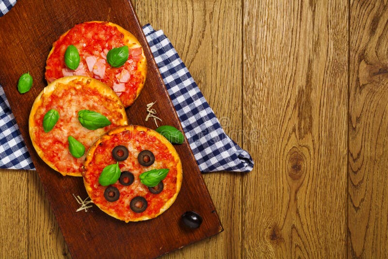 Mix of Mini Pizzas on Wooden Board Stock Photo - Image of salami, food ...