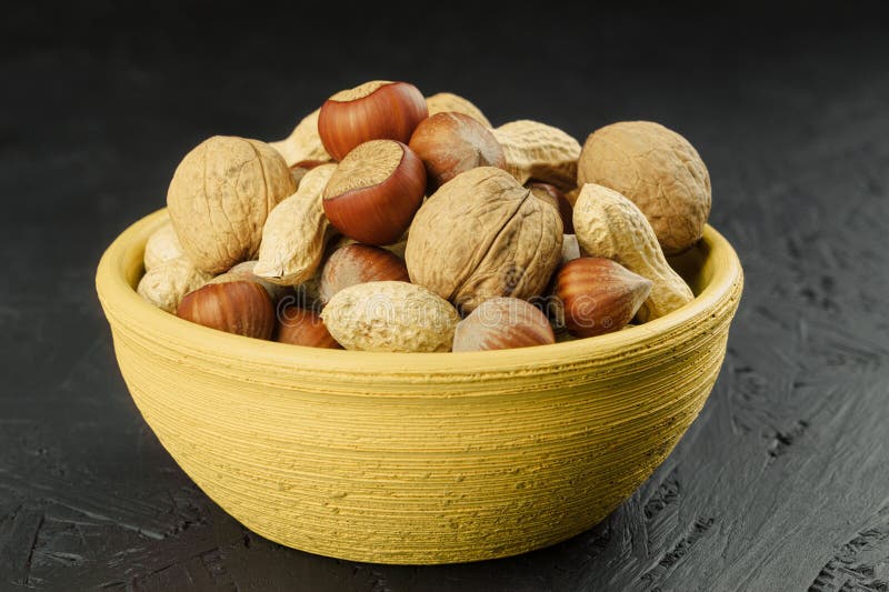 A Mix of Nuts in a Shell, in a Clay Plate Stock Photo - Image of ...