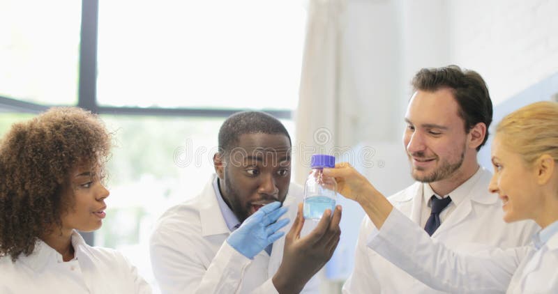 Mix Race Scientists Team Analyzing Liquid in Bottle Talking Happy ...