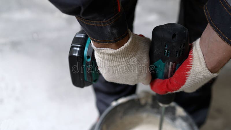 Close-up of Mixing a Solution with a Mixer in a Bucket. the Builder ...