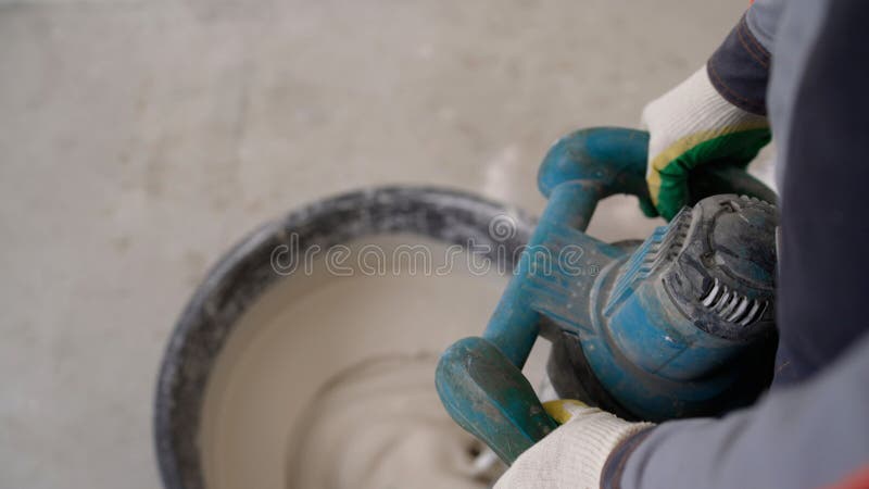 The Worker Mixes the Self-leveling Floor Mortar in a Bucket. Mix the ...
