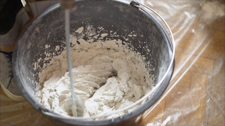 Mix the Solution in a Bucket Using a Construction Mixer. Worker Mixing ...