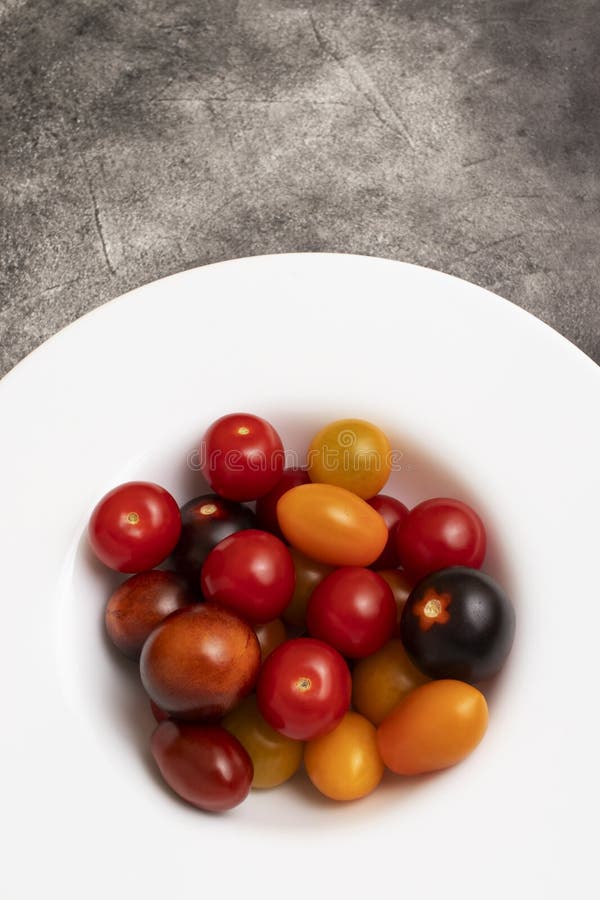 Mix of Yellow, Red and Black Cherry Tomatoes in a White Plate. Stock ...