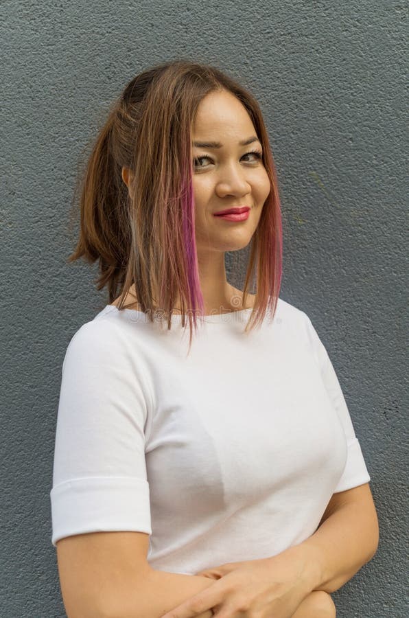 A Mixed Race Asian Girl With Slanting Eyes And Mean Smile Posing