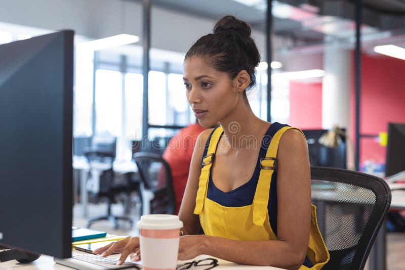 Mixed Race Female Creative Worker Sitting at Desk Using Computer Stock ...