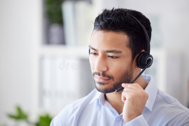 A Mixed Race Man Working in a Call Center. Operator Using a Wireless ...