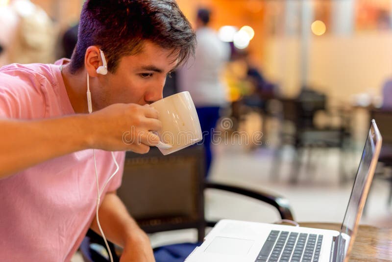 Mixed Race Studen Drinking Coffee while Working on Computer Lapt Stock ...