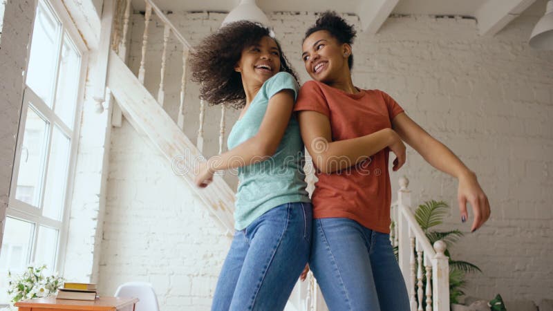Mixed Race Young Beautiful Girls Dancing On A Bed Together Having Fun