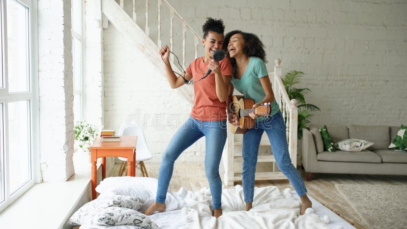 Curly Funny African American Girl Dancing And Singing With Hair Dryer
