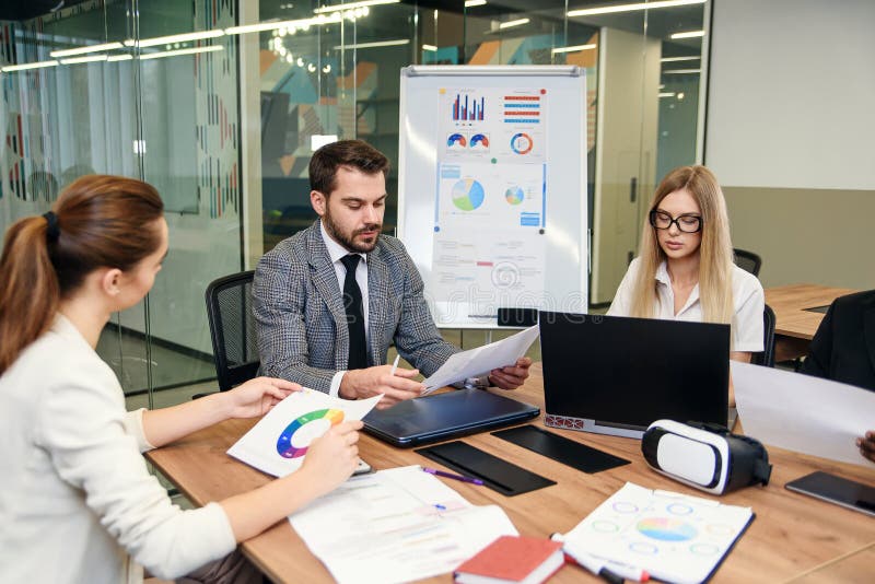 Mixed Races Coworkers Analysing Different Business Papers and Working ...