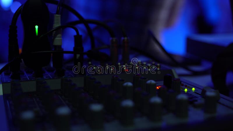 Mixing Console with Glowing LEDs and Dancing People in Neon Light ...