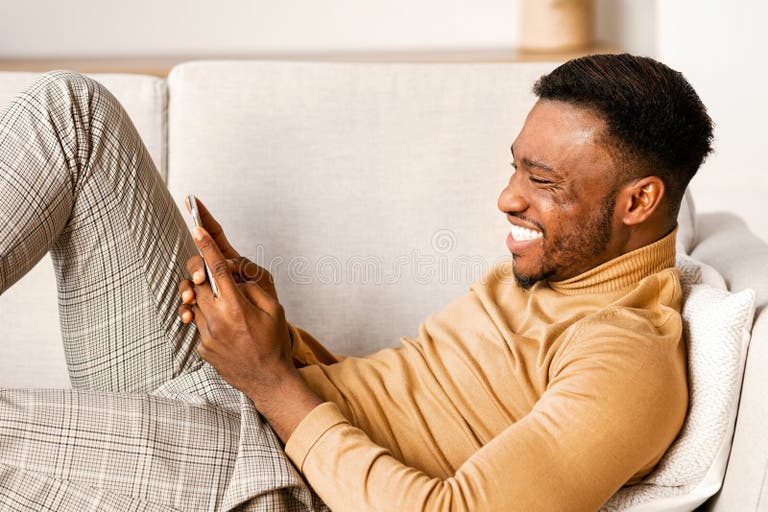 Relaxed Guy Using Smartphone Lying on Sofa at Home Stock Image - Image ...