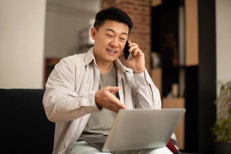 Mobile Communication. Middle Aged Asian Man Talking on Cellphone and ...