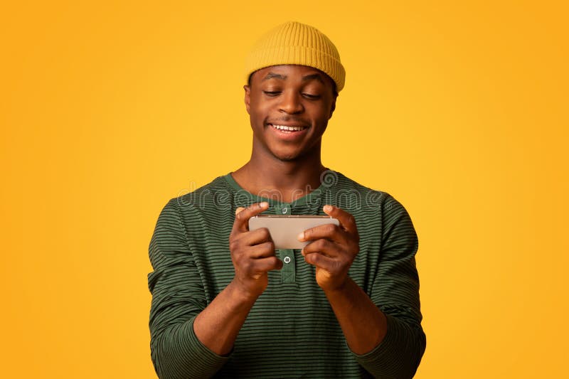 Mobile Gaming Concept. Excited Young Black Guy Playing Online Games on ... Mobile Gaming Concept. Excited Young Black Guy Playing Online Games on ...