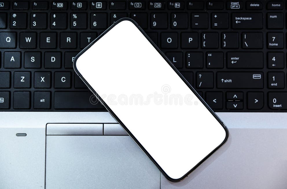 Mobile on a Laptop Keyboard with White Screen As Placeholder ...