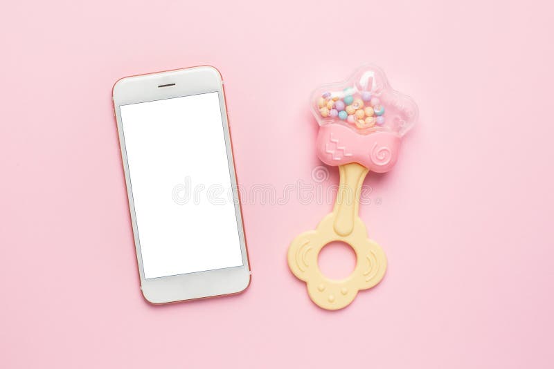 Mobile Phone and Baby Rattle with Teether on Pink Background Stock ...