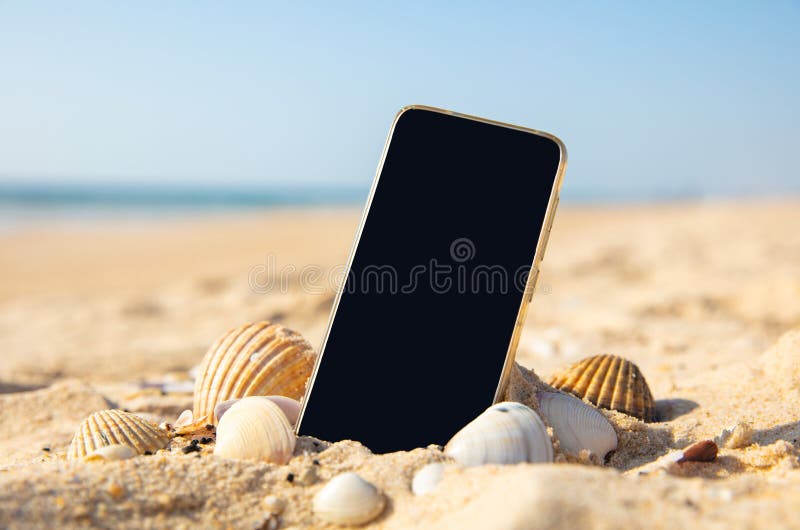 Mobile phone on the beach stock photo. Image of break - 321144544