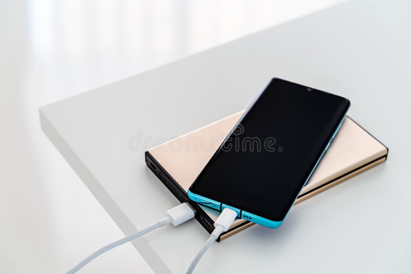 Mobile Phone Connected To Charger Power Bank on White Table Stock Photo ...