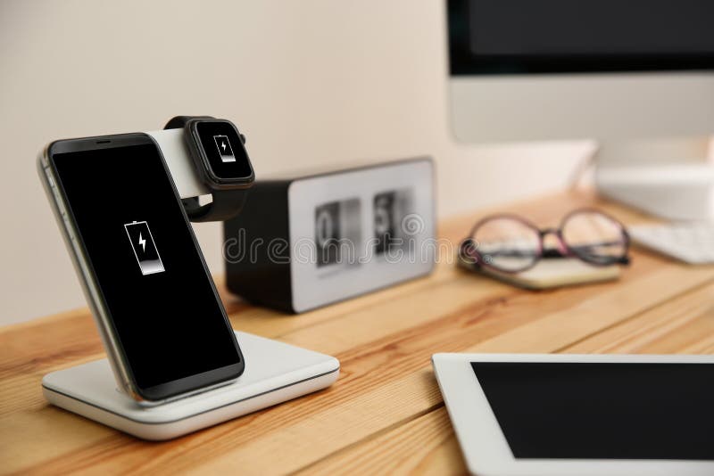 Mobile Phone and Smartwatch with Wireless Charger on Table. Modern ...