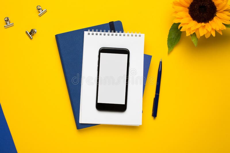 Mobile Phone With White Notepad , Blue Notebook And Pen On Yellow ...