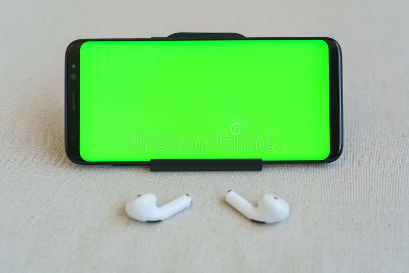 Mobile Phone and Wireless Headphones Stand on Table Stock Image - Image ...