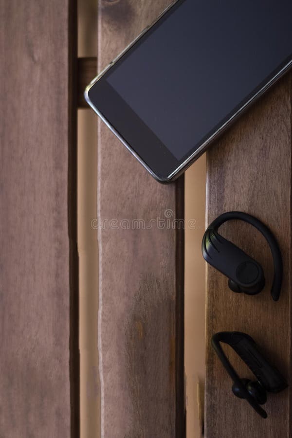 Mobile Phone and Wireless Headphones on a Wooden Table Stock Photo ...