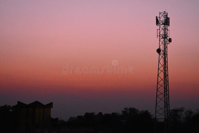A Mobile Tower Standing between the Trees Captured during Sunset Stock ...