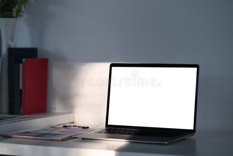 Laptop Computer with Blank Screen on White Desk at Dark Office Room ...