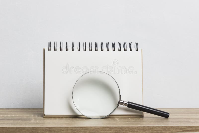 Mock Up White Note and Magnifying Glass on a Wooden Table Over the ...