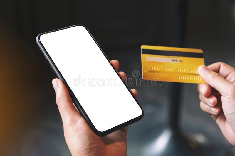 A Hands Holding Credit Card and a Black Mobile Phone with Blank Desktop ...