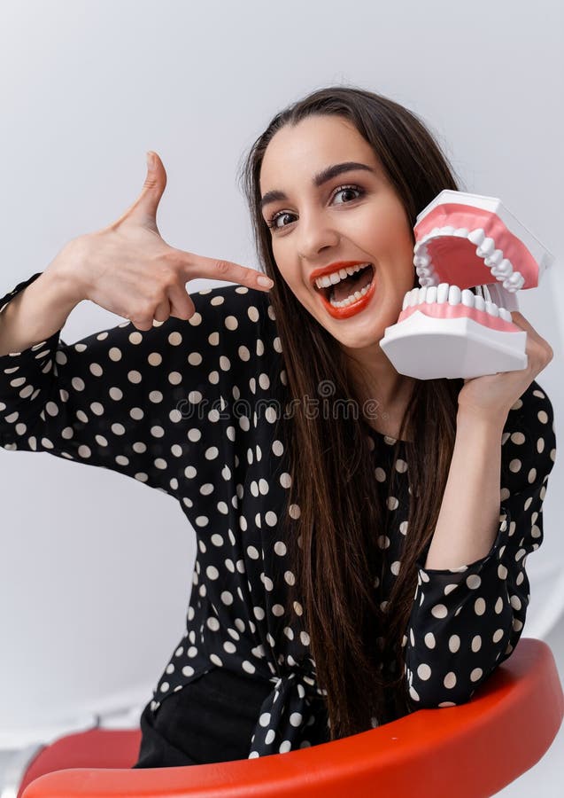 Model of Artificial Jaw with Teeth in Hands. White Cabinet Background ...