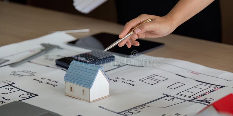 Model Building and Project Planning. a Hand Points To a Miniature House ...