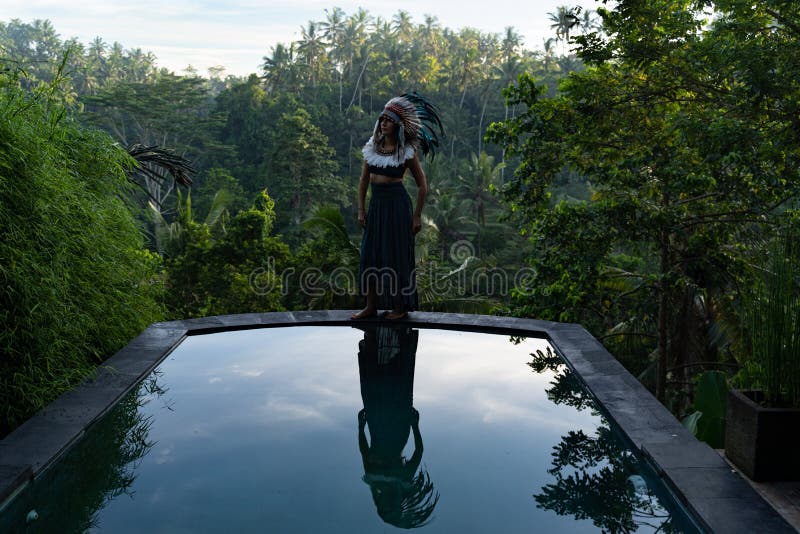 Model Dressed in American Indian Posing on an Edge of Infinity Pool in ...