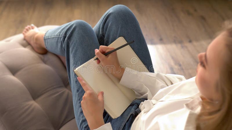 Model Poses Sitting on a Rock in the Sea with a Magnificent View in the ...